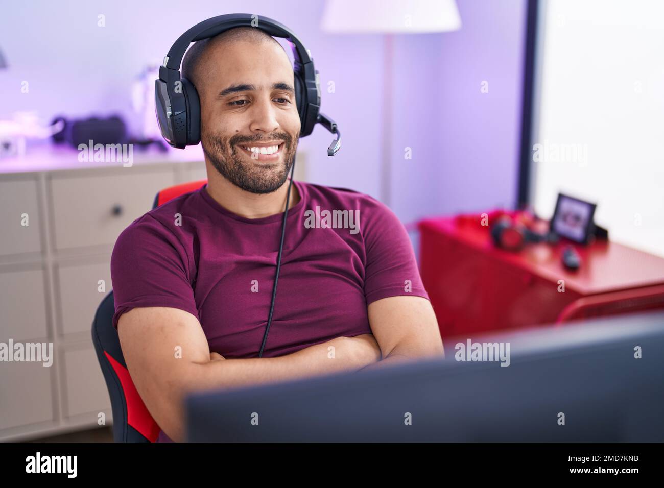 Young latin man streamer smiling confident sitting with arms crossed ...