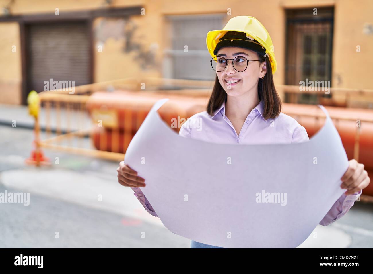 Young hispanic woman architect reading plans at street Stock Photo - Alamy