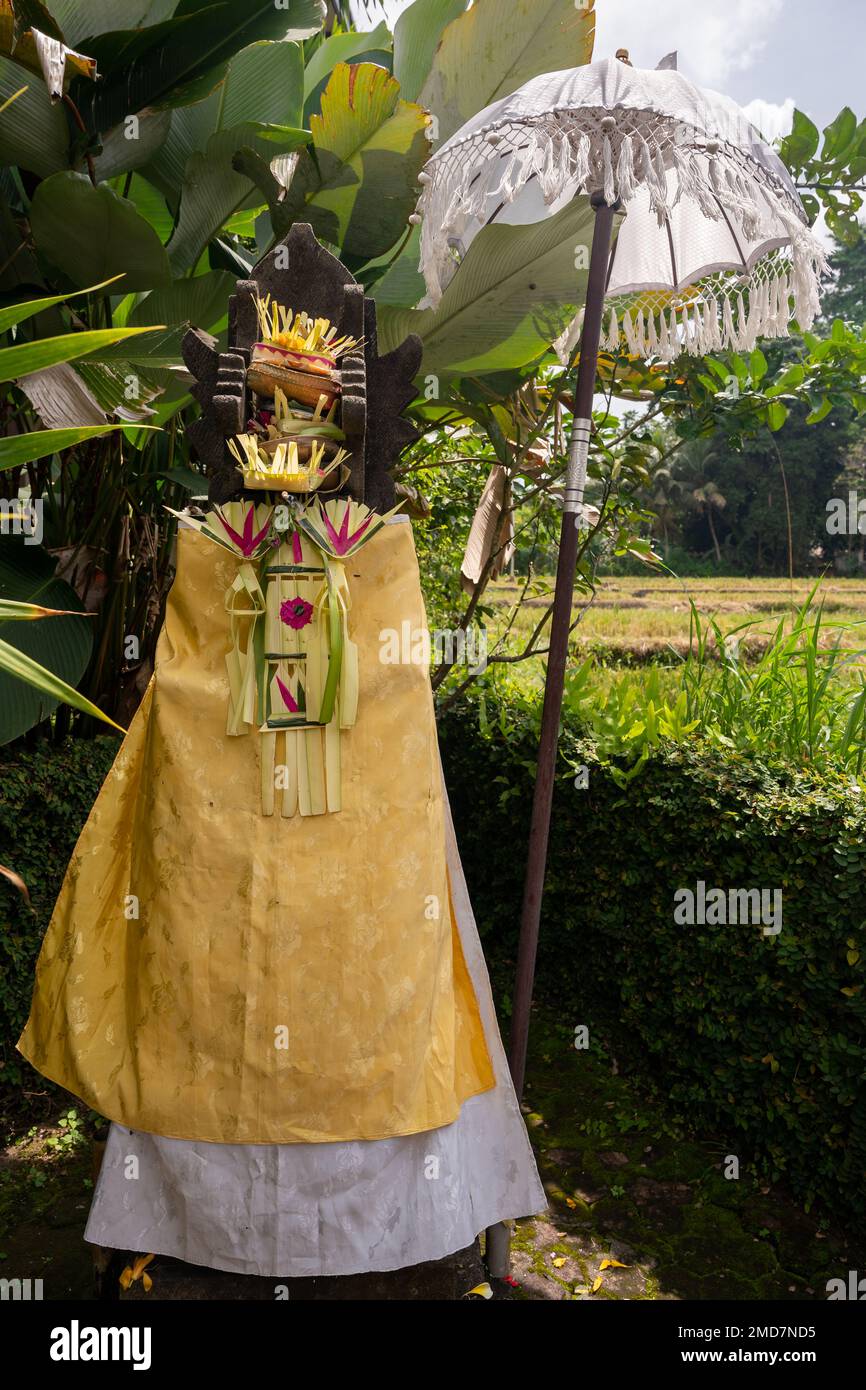 A traditional altar in Bali, Indonesia, decorated with yellow fabric ...
