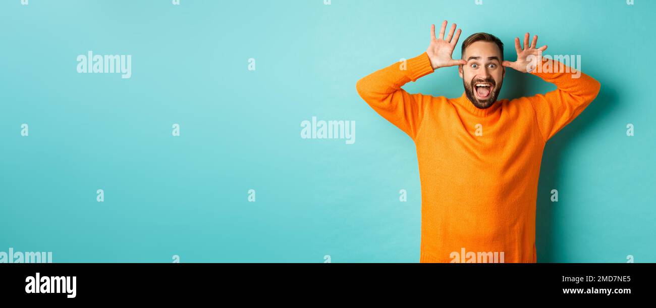 Image of handsome caucasian man making funny faces, mocking someone and ...