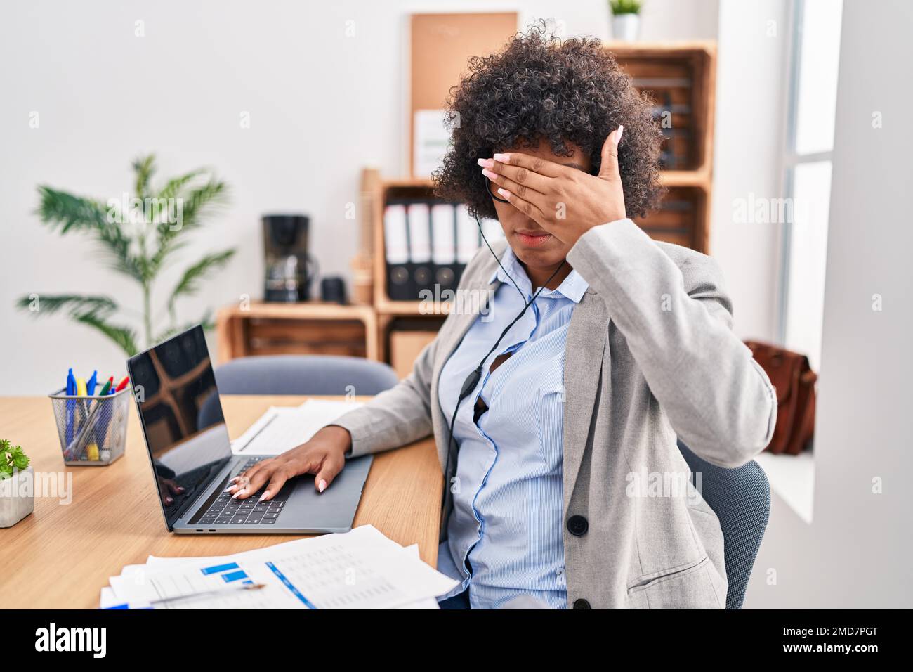 Black woman with curly hair wearing call center agent headset at the ...