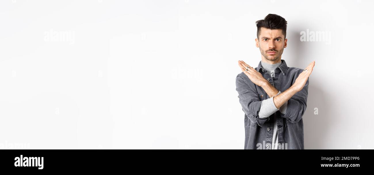 Angry man show cross gesture to stop or say no, frowning and looking ...