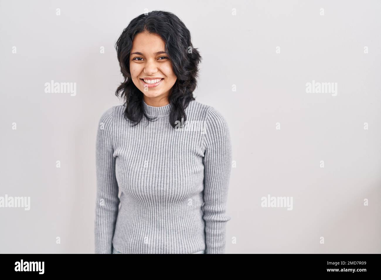 Hispanic woman with dark hair standing over isolated background with a ...