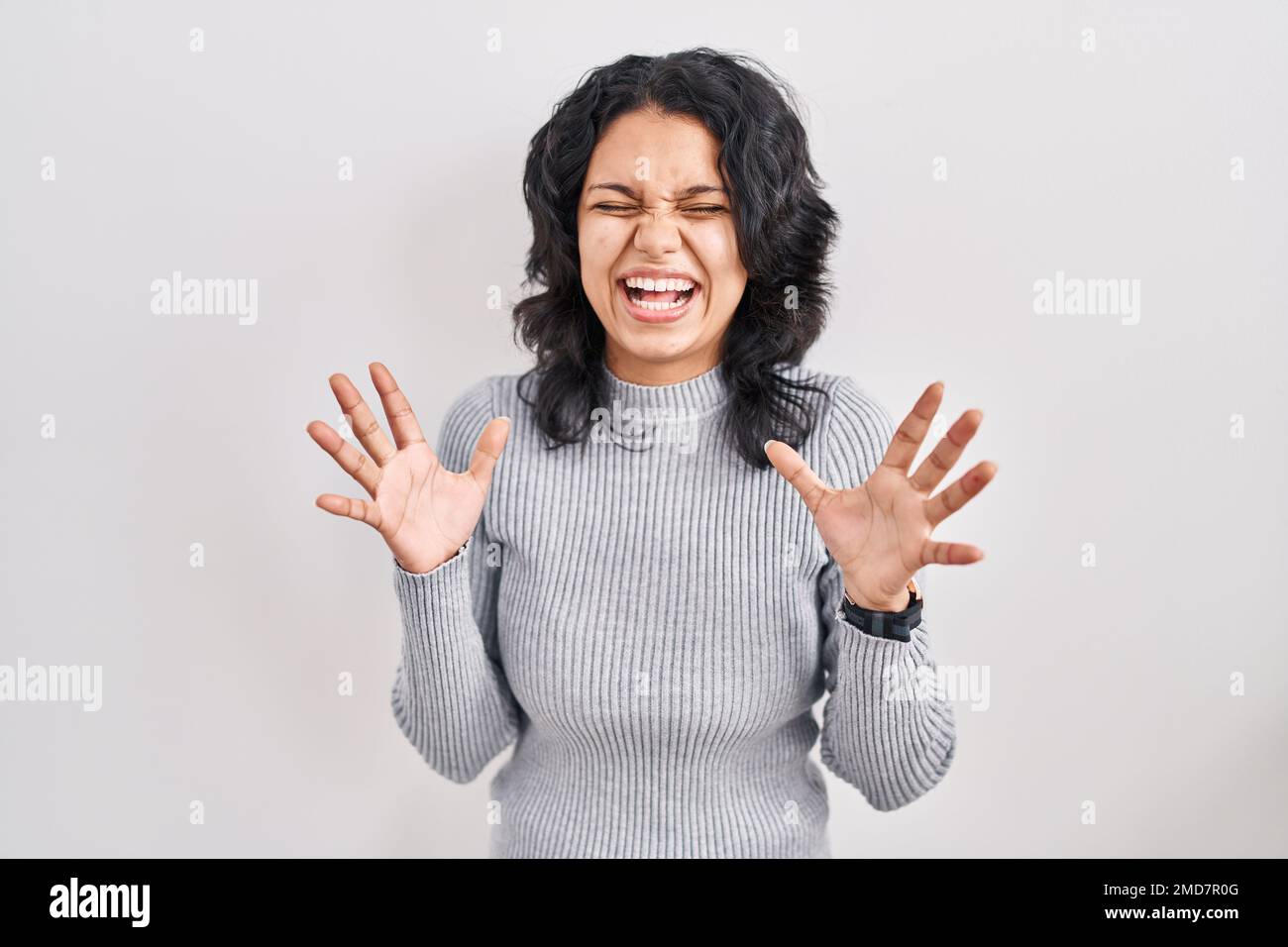 Hispanic woman with dark hair standing over isolated background ...