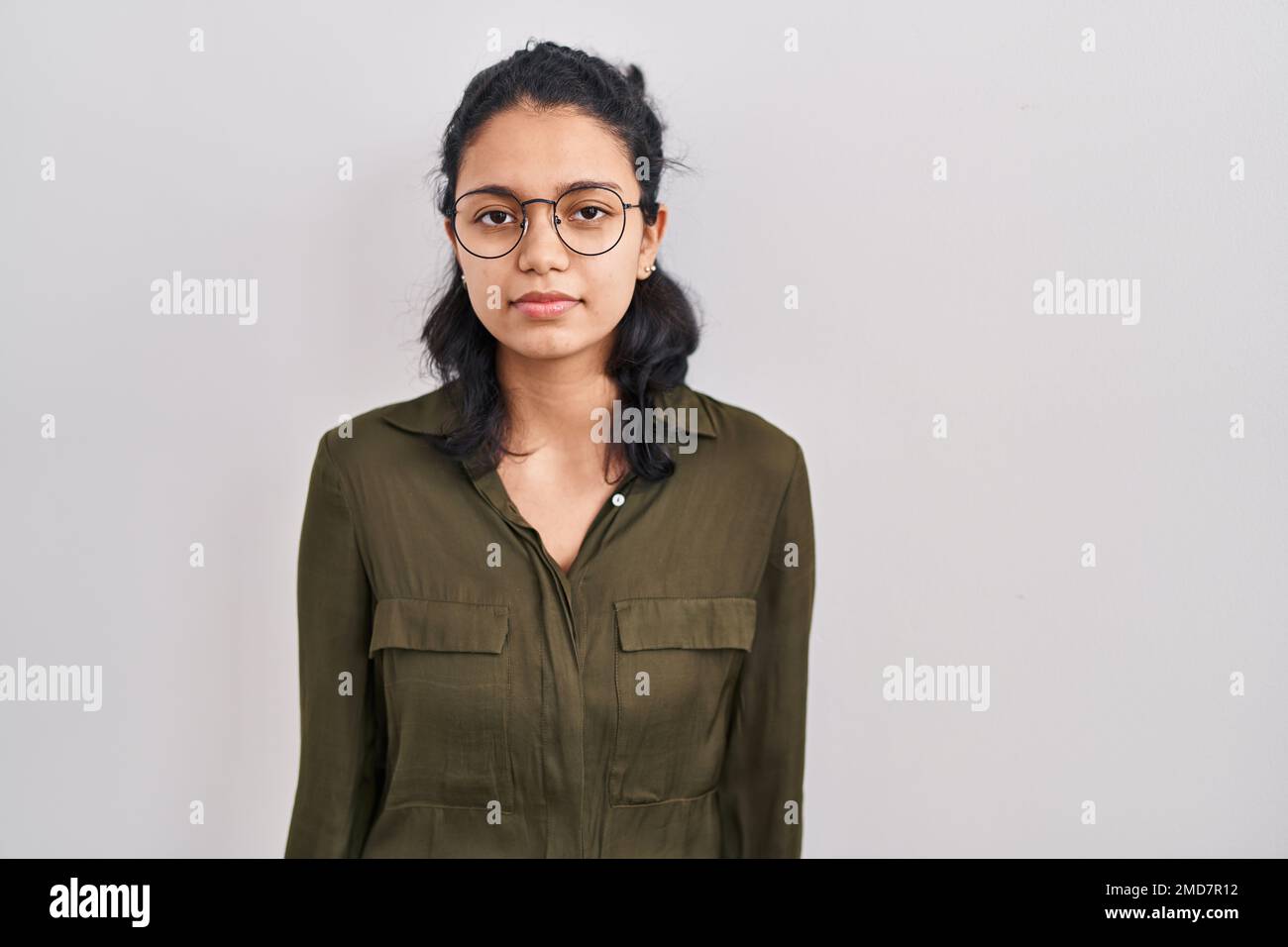 Hispanic woman with dark hair standing over isolated background relaxed ...