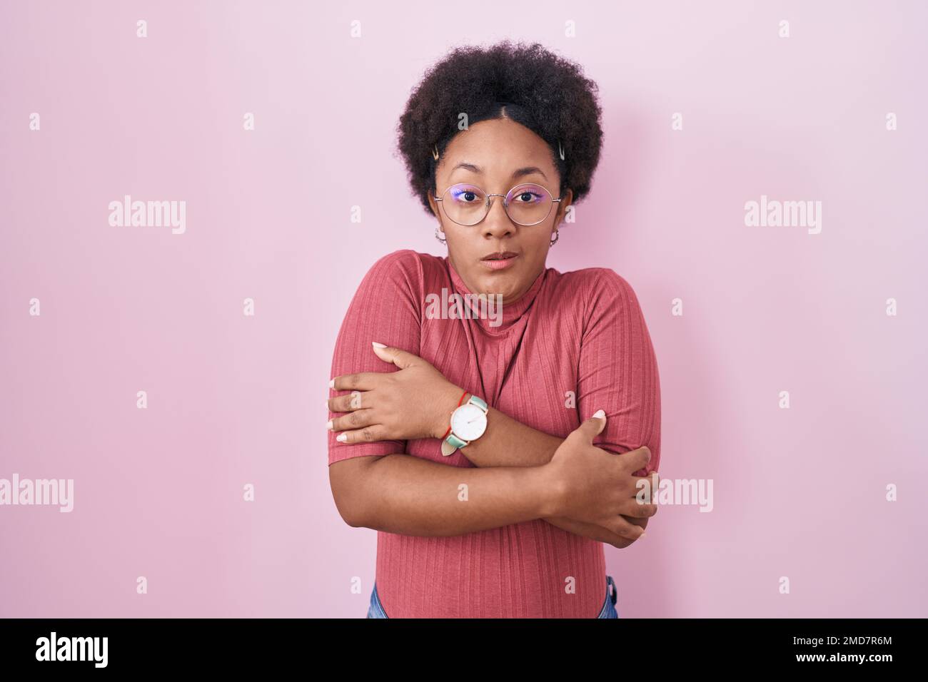 Beautiful african woman with curly hair standing over pink background ...