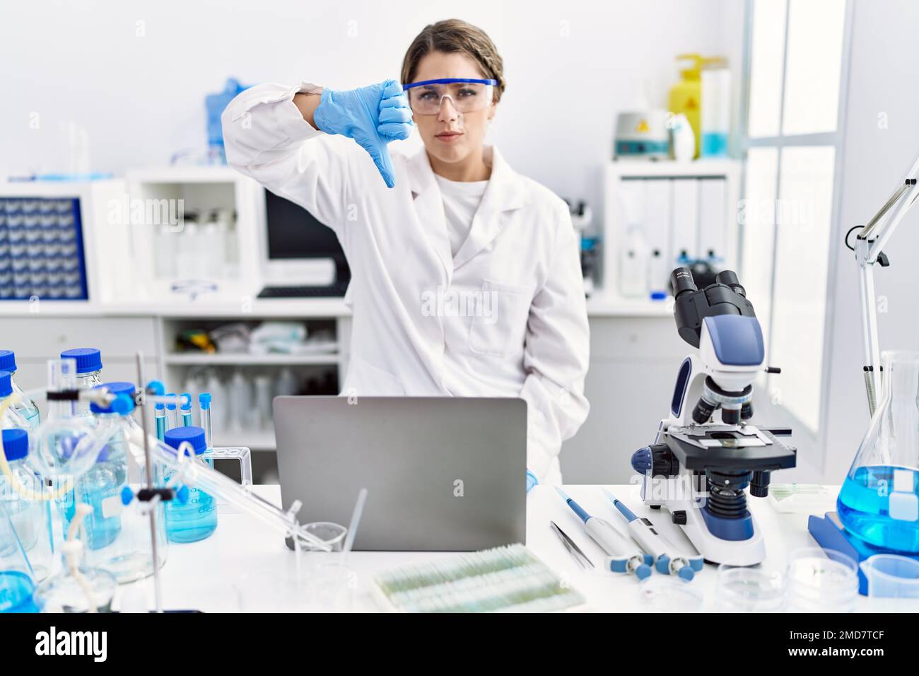 Young hispanic woman wearing scientist uniform working at laboratory ...