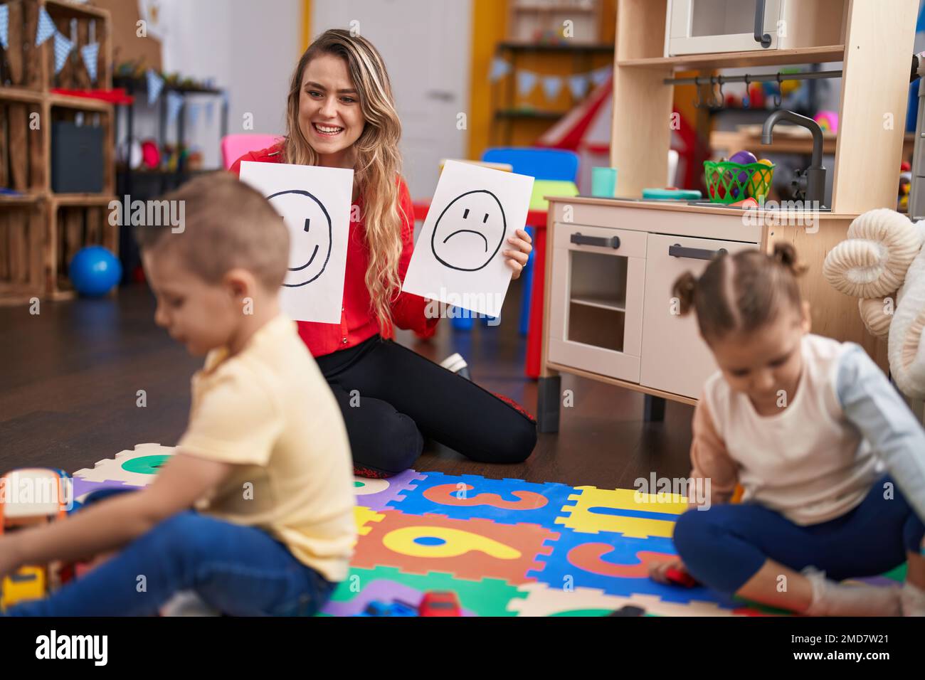 Teacher with boy and girl sitting on table having emotion therapy at ...