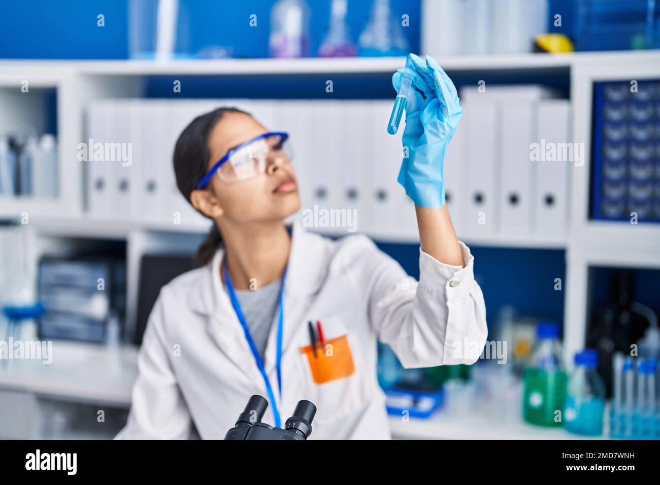 Young african american woman scientist measuring liquid at laboratory ...