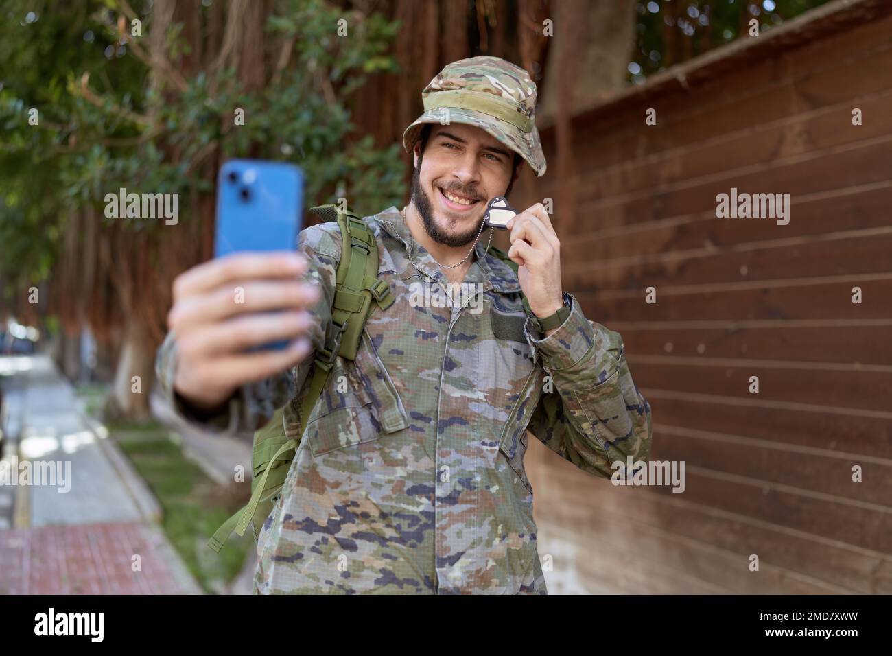 Young hispanic man wearing soldier uniform make selfie by smartphone at ...