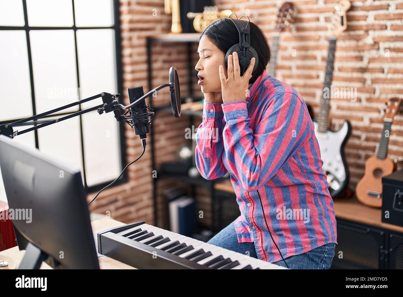 Young chinese woman artist singing song at music studio Stock Photo - Alamy