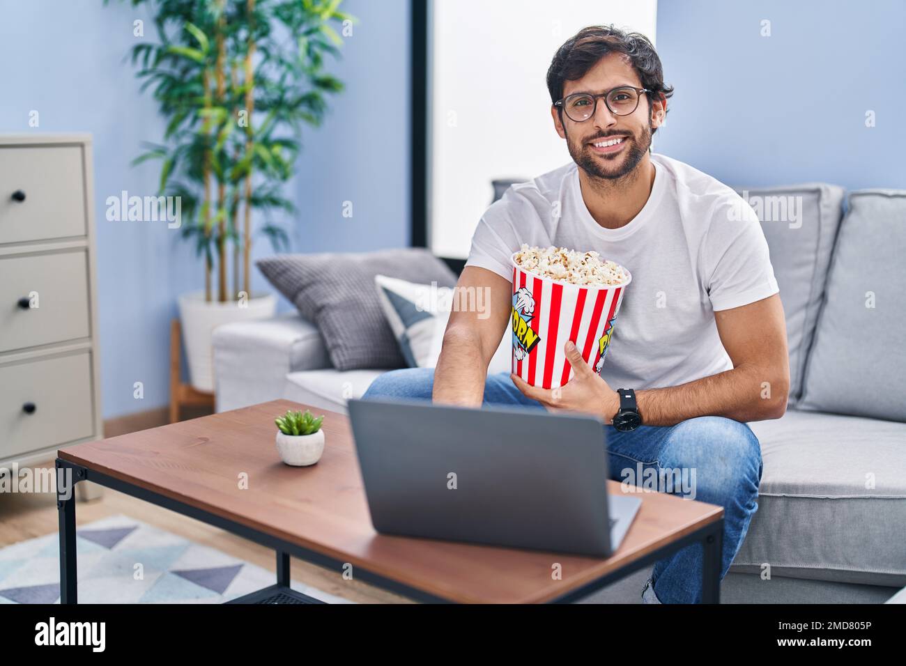 Indian man eating popcorn watching hi-res stock photography and images ...