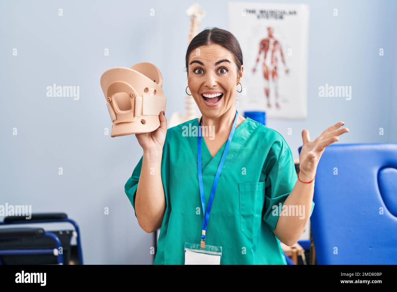 Young hispanic woman holding cervical neck collar at the clinic ...