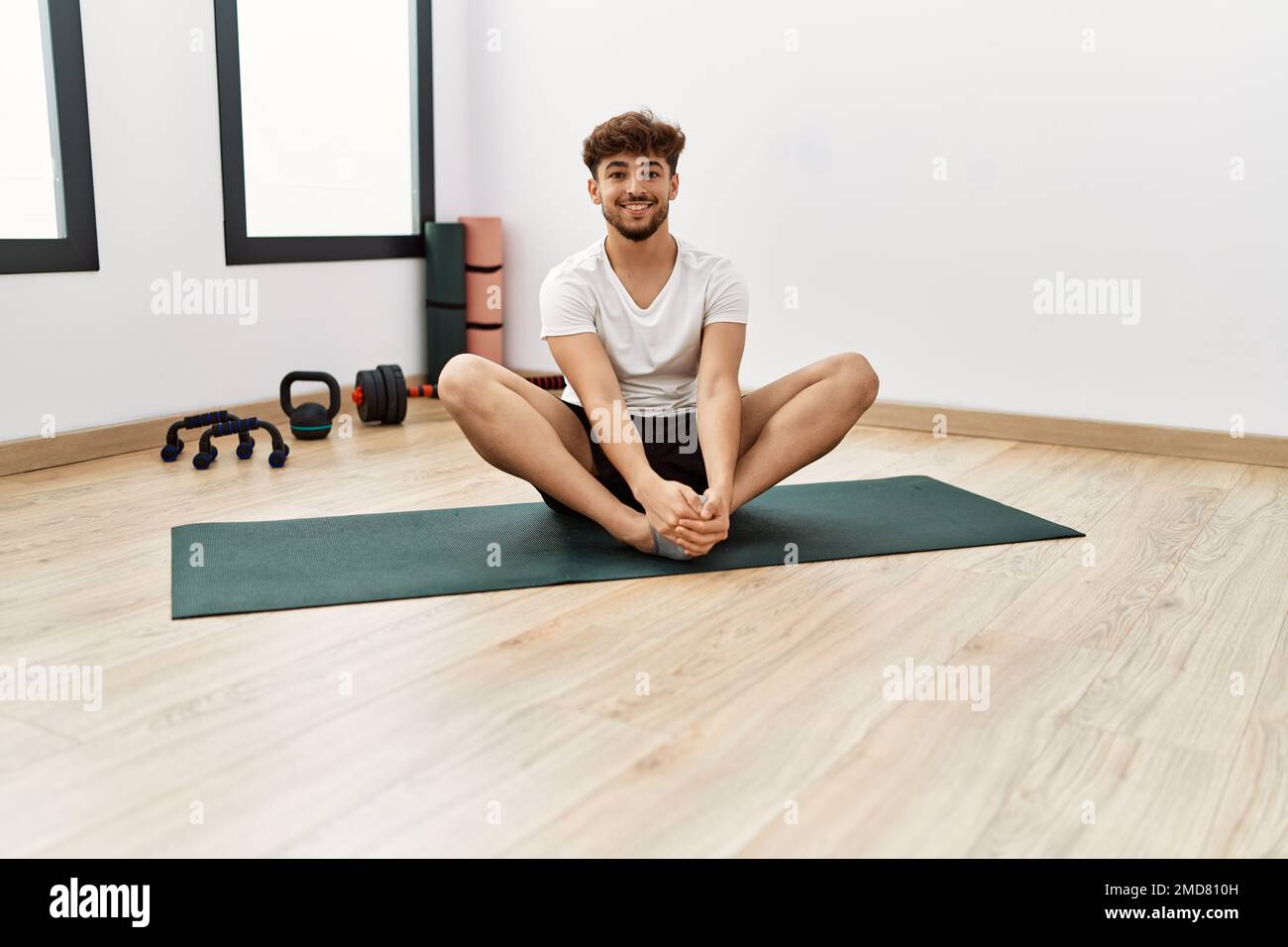 Young arab man smiling confident stretching at sport center Stock Photo ...