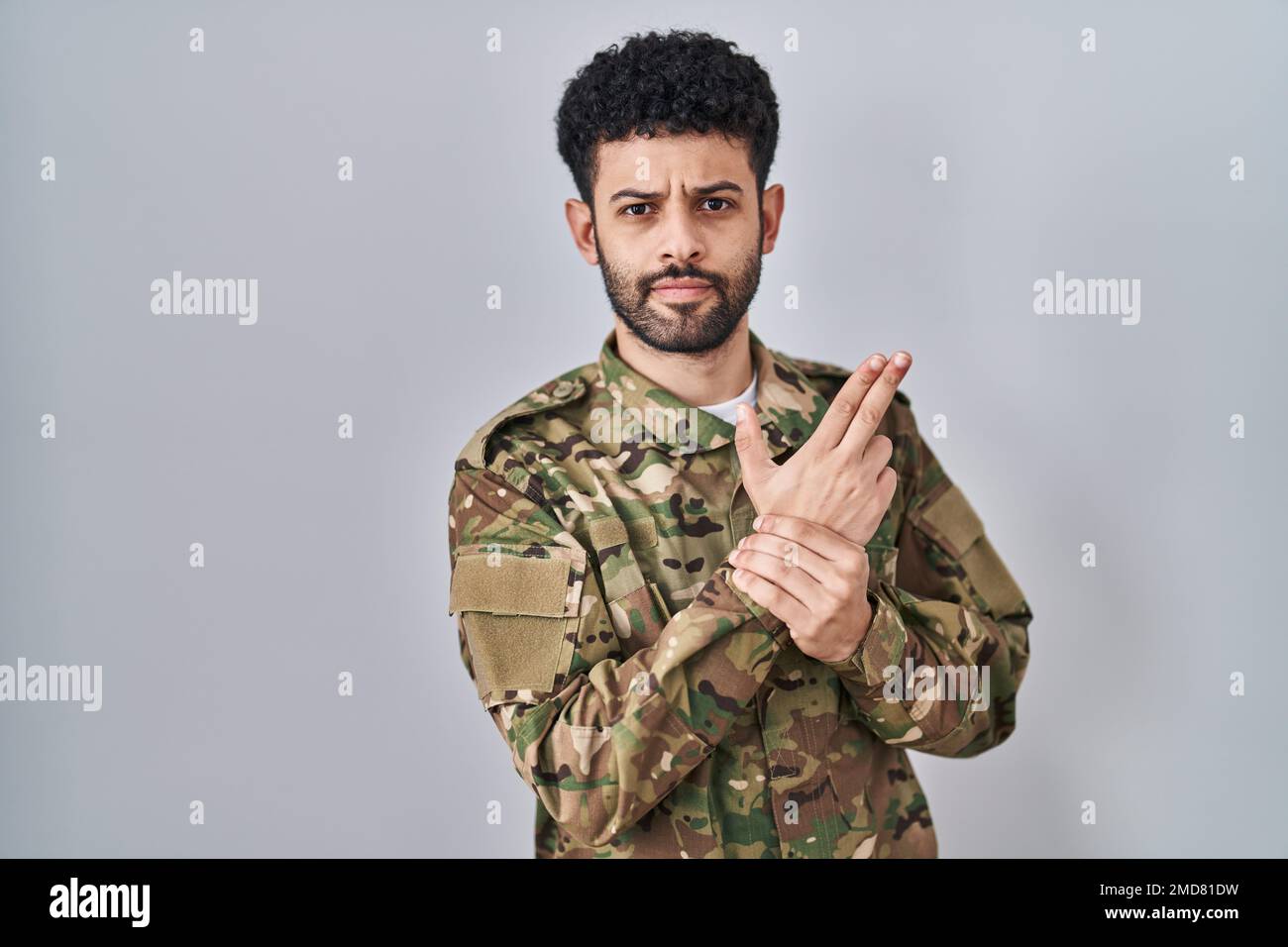 Arab man wearing camouflage army uniform holding symbolic gun with hand ...