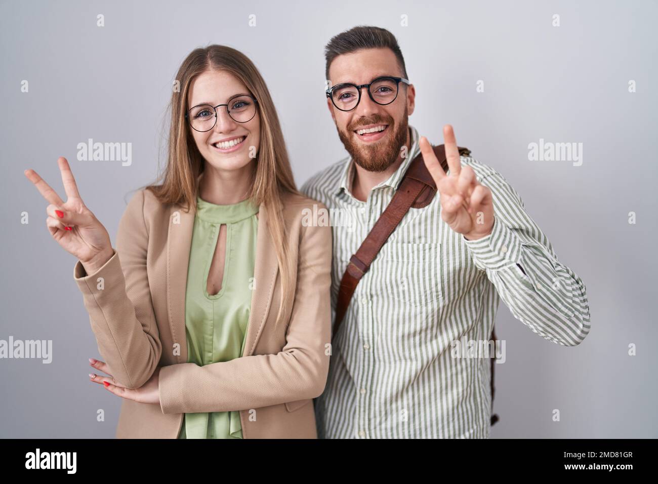 Young couple standing over white background smiling with happy face ...
