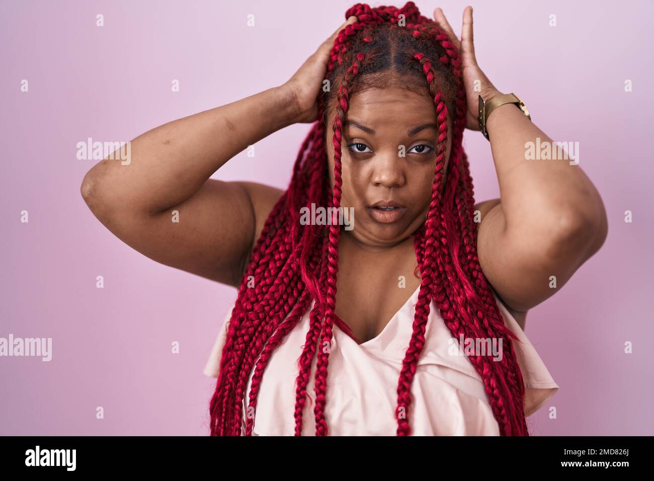 African american woman with braided hair standing over pink background ...