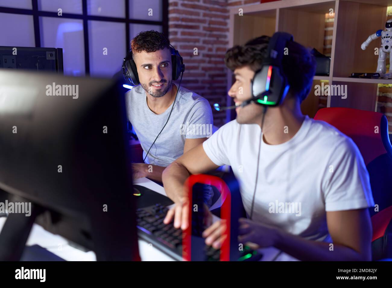 Two hispanic men streamers playing video game using computer at gaming ...