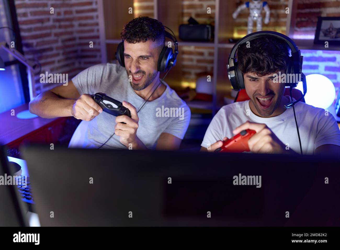 Two hispanic men streamers playing video game using joystick at gaming ...