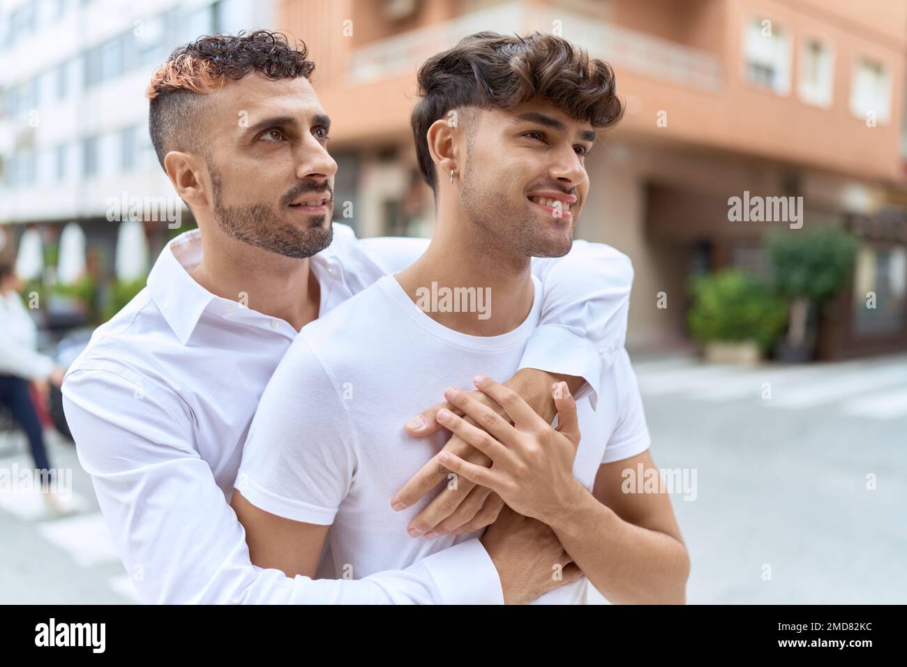 Two hispanic men couple smiling confident hugging each other at street ...