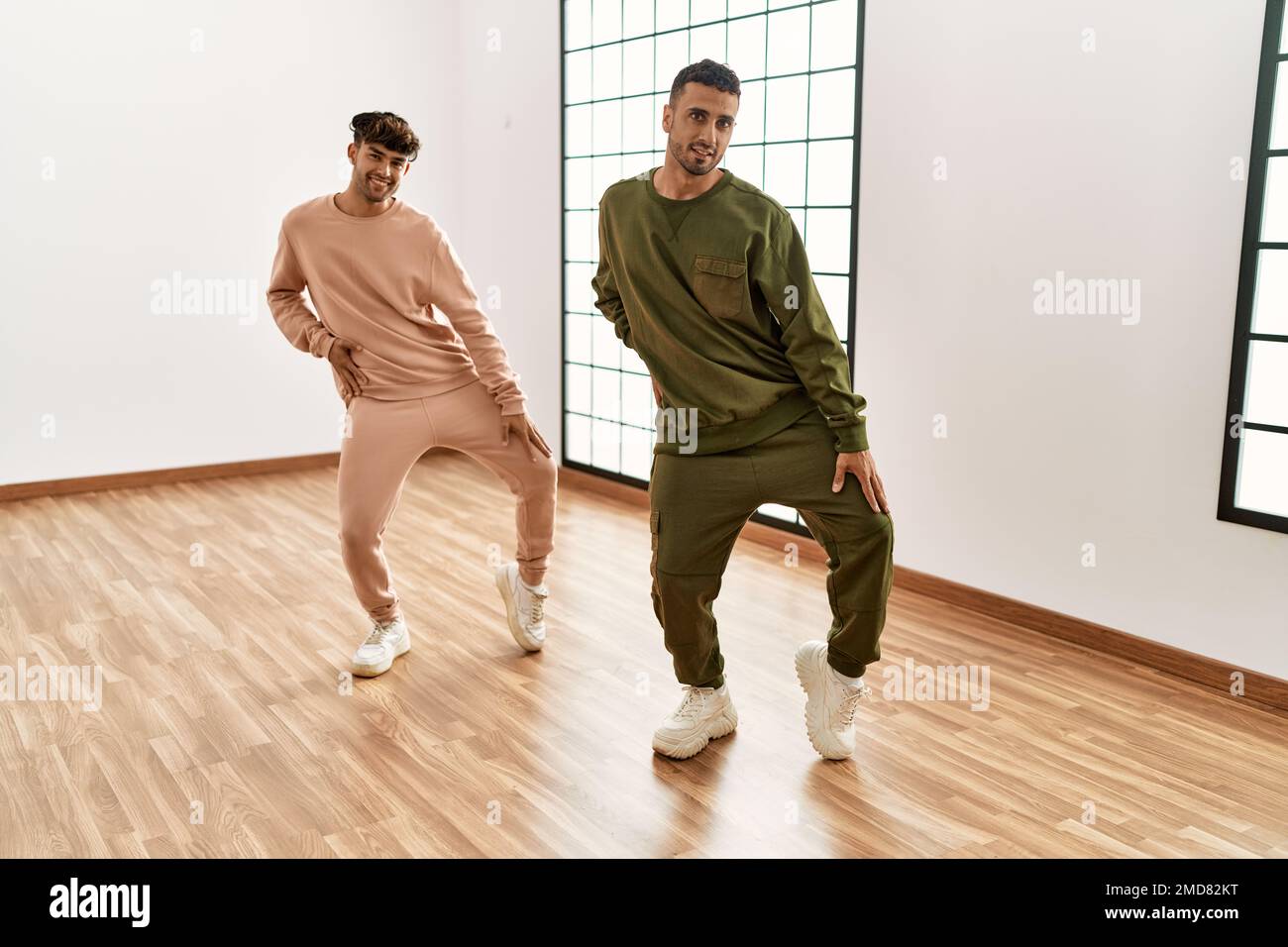 Two hispanic men couple dancers smiling confident dancing at sport ...