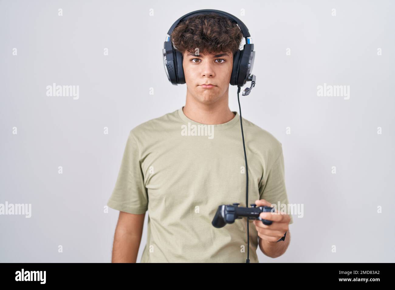 Hispanic teenager playing video game holding controller depressed and ...