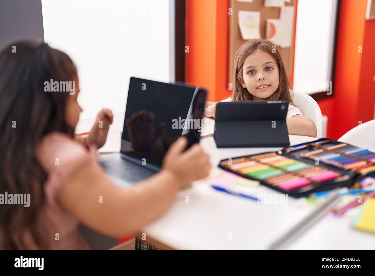 Two kids students using laptop and touchpad studying at classroom Stock ...