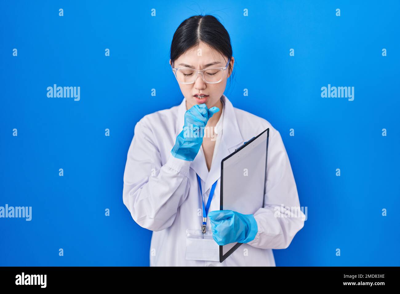 Chinese young woman working at scientist laboratory feeling unwell and ...