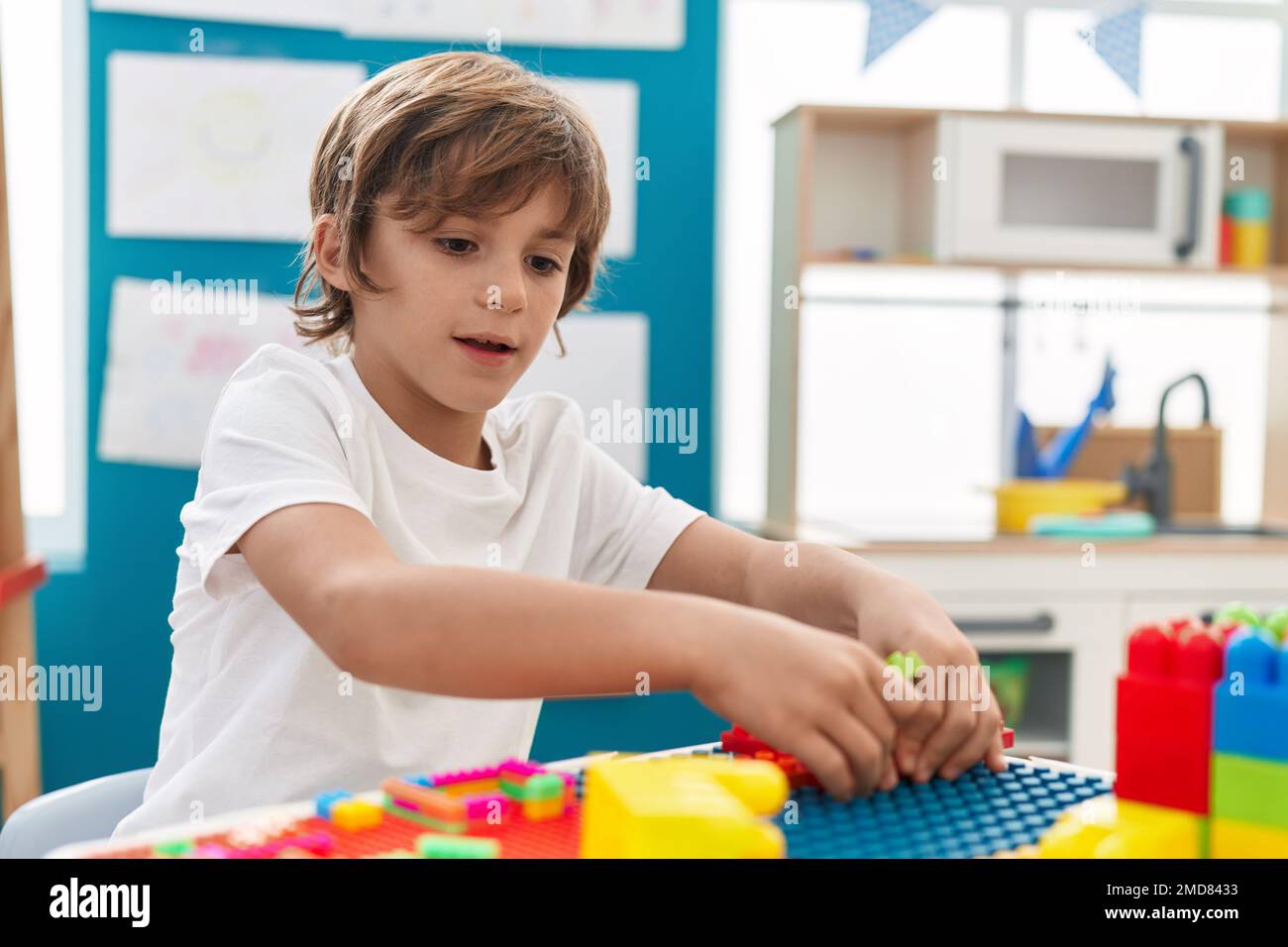 Adorable caucasian boy playing with construction blocks sitting on ...