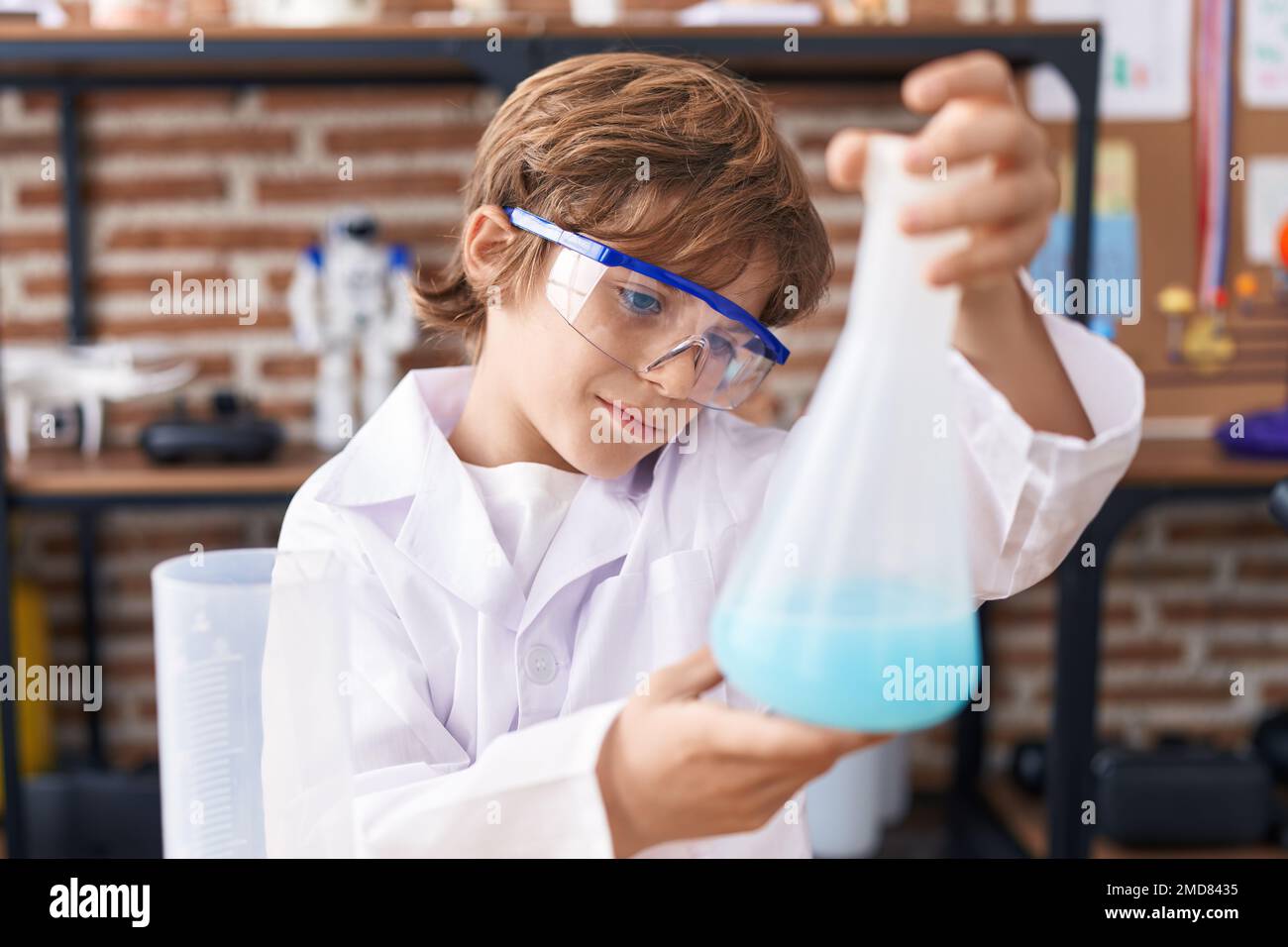 Adorable caucasian boy student holding test tube at classroom Stock ...
