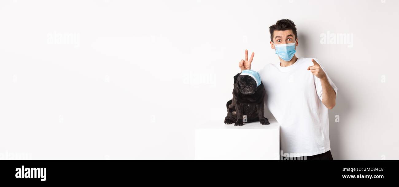 Covid-19, animals and quarantine concept. Happy dog owner and cute pug ...