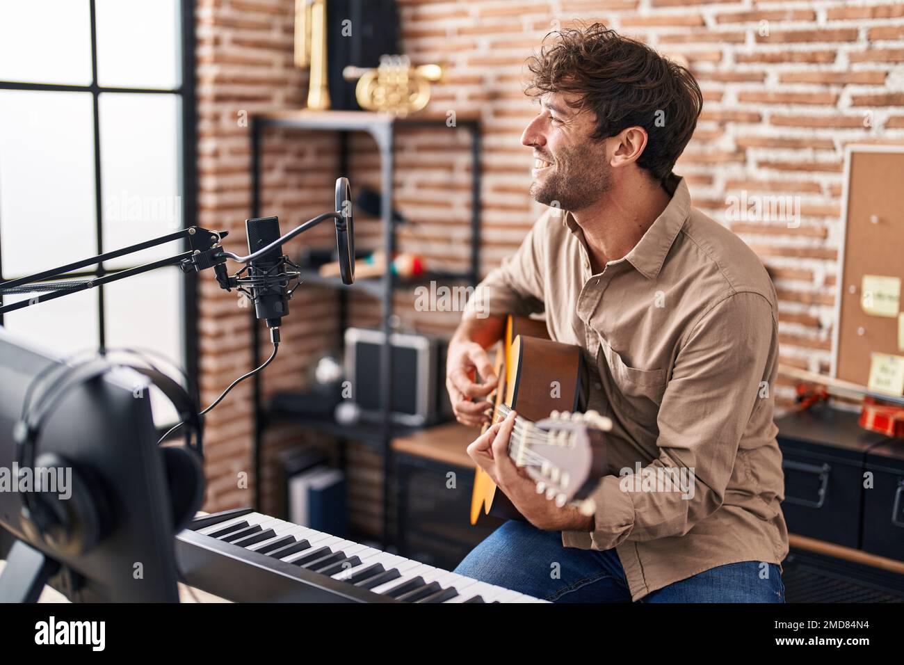 Young man musician singing song playing classical guitar at music ...