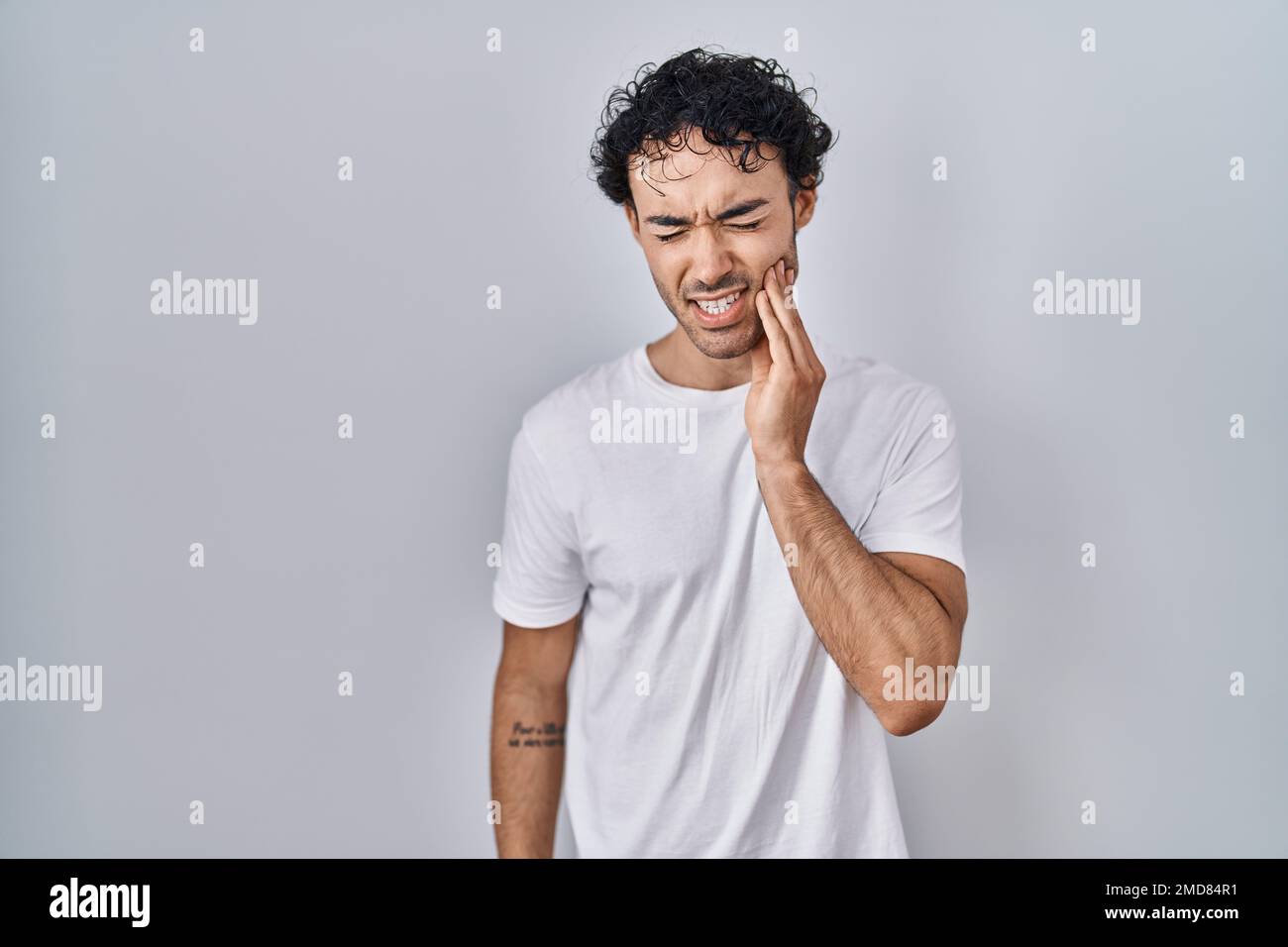Hispanic man standing over isolated background touching mouth with hand ...