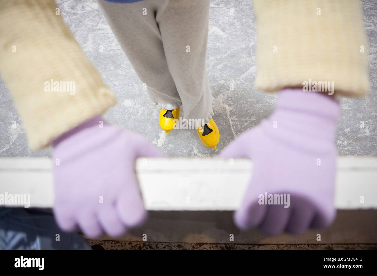 Children enjoy skating on ice. Focus on yellow ice skates Stock Photo ...