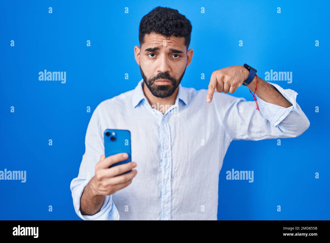 Hispanic Man With Beard Using Smartphone Typing Message Pointing Down
