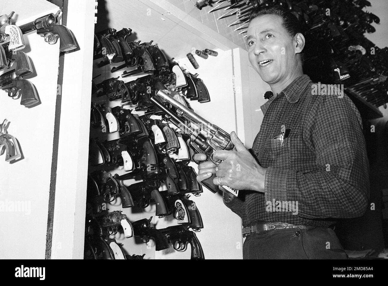 FILE - In this Aug. 13, 1958, file photo, selecting a pair of six-guns ...