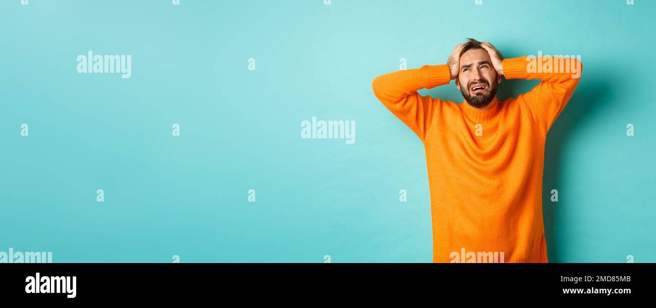 Frustrated and desperate man holding hands on head, looking sad and ...