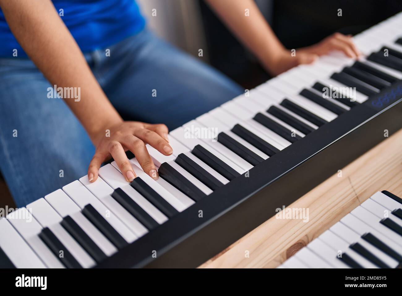 Young chinese woman musician playing piano keyboard at music studio ...