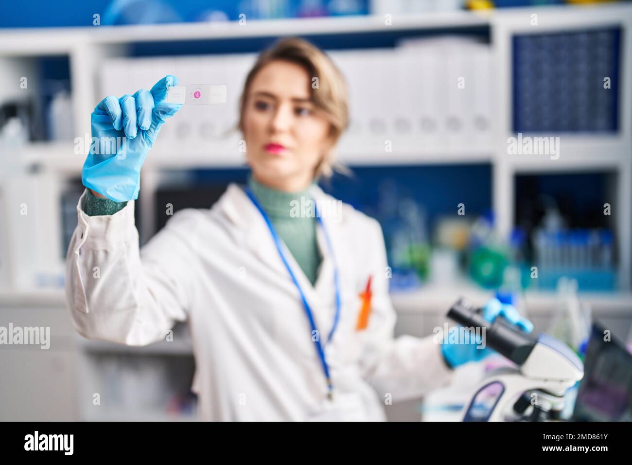 Young woman scientist using microscope looking sample at laboratory ...