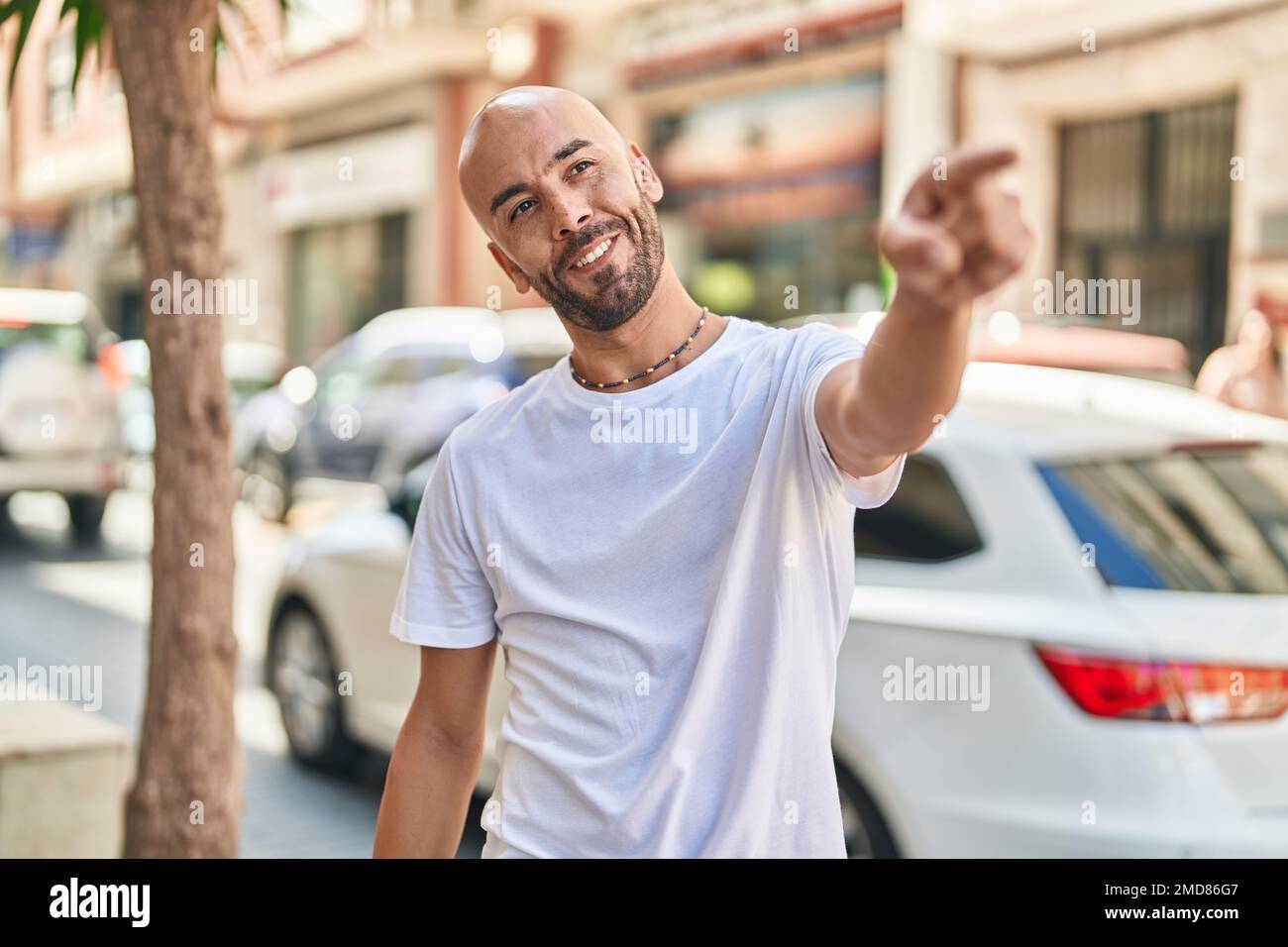 Young bald man smiling confident pointing with finger at street Stock ...