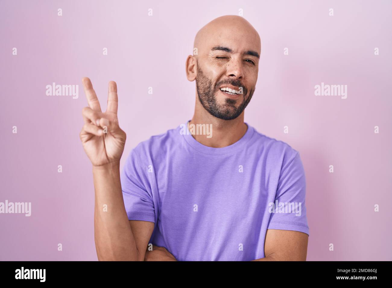 Middle age bald man standing over pink background smiling with happy ...
