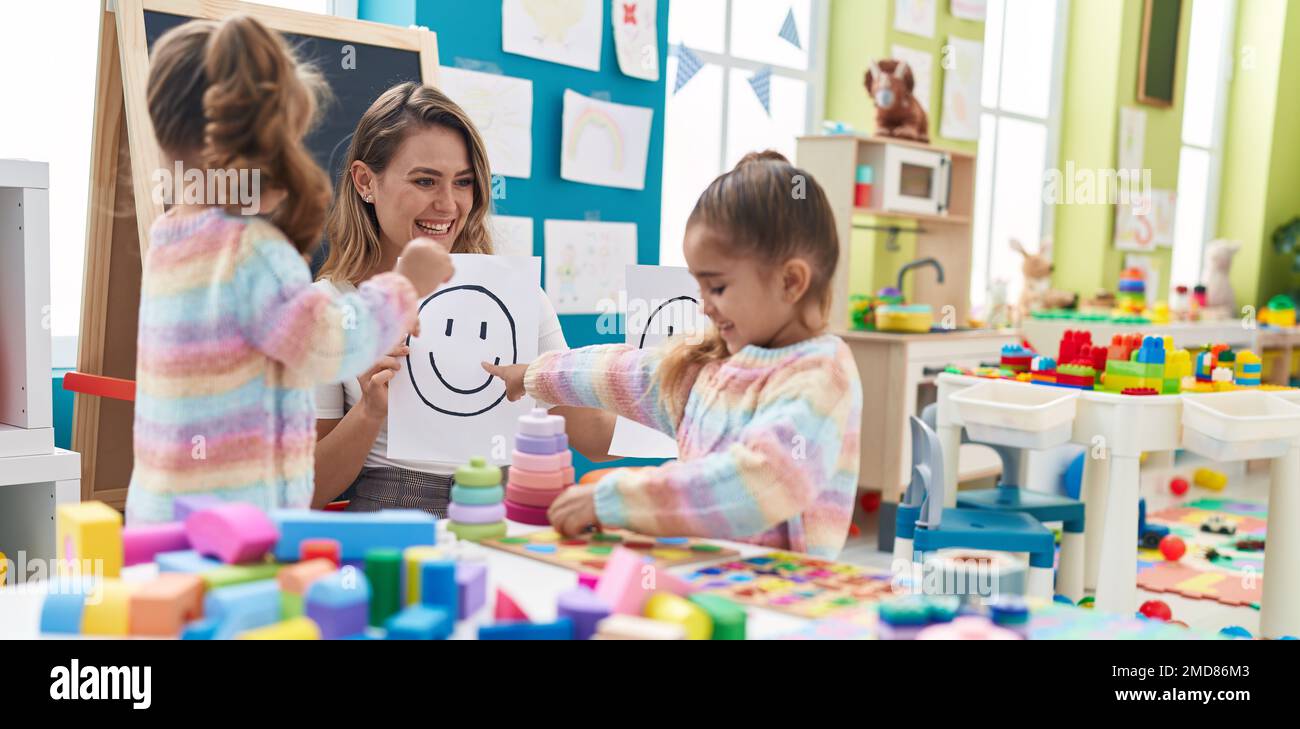 Teacher with girls sitting on table having emotion therapy at ...