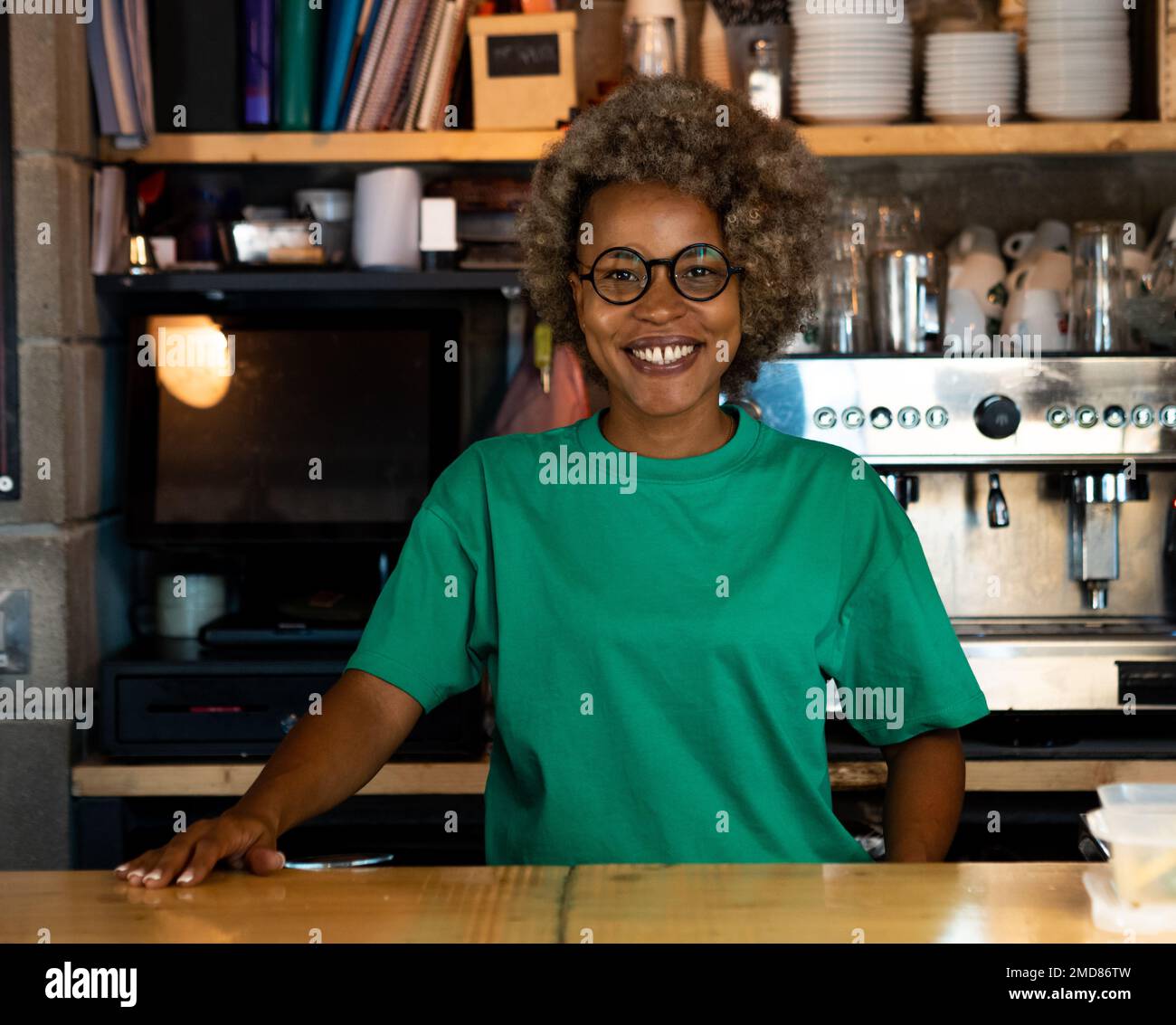 Portrait of a smiling African American woman waitress with afro hair in ...