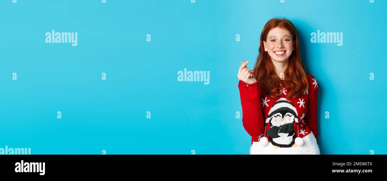 Winter holidays and Christmas Eve concept. Cute smiling redhead girl in ...