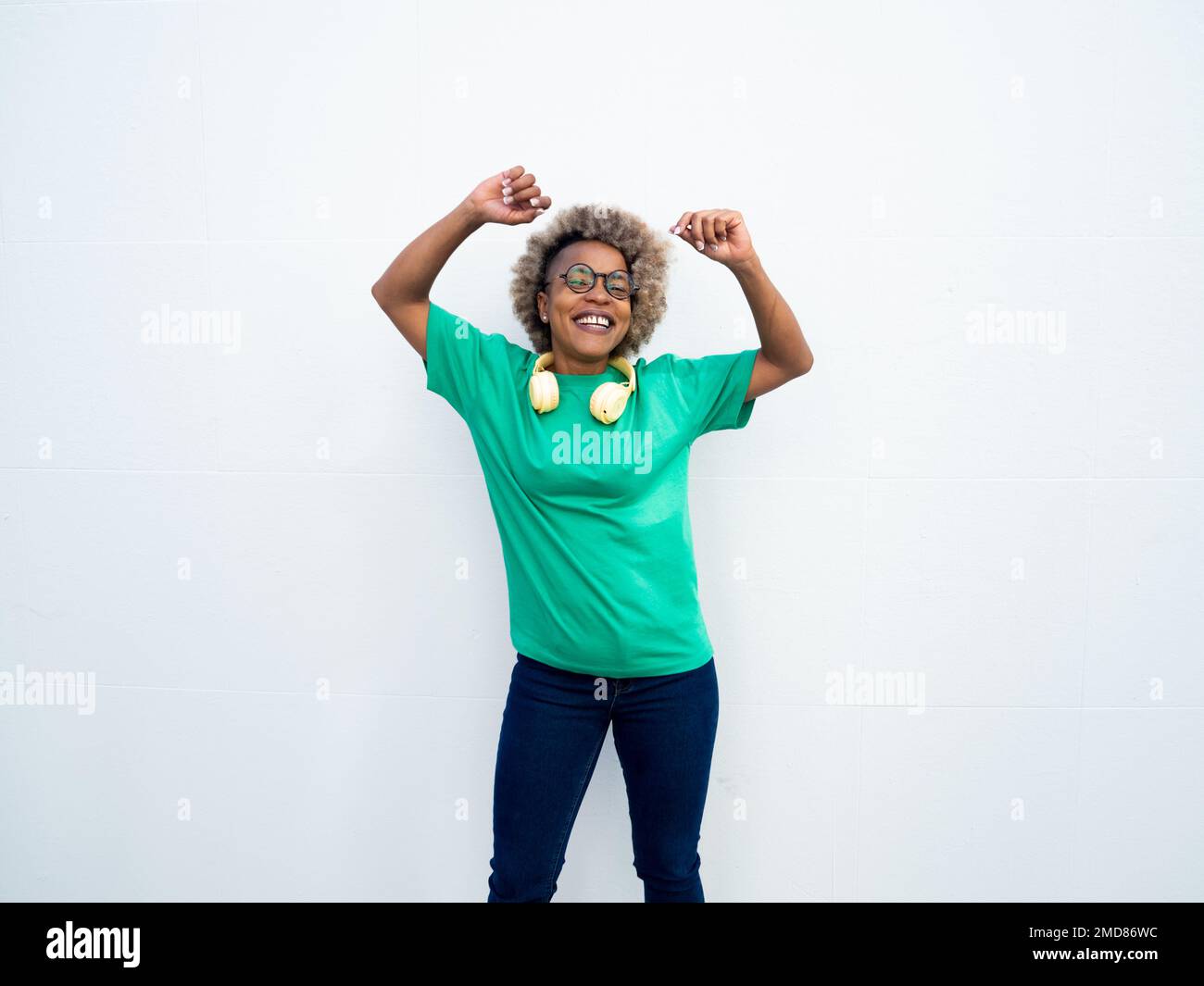 Cheerful african american young woman with afro hair and headphones ...