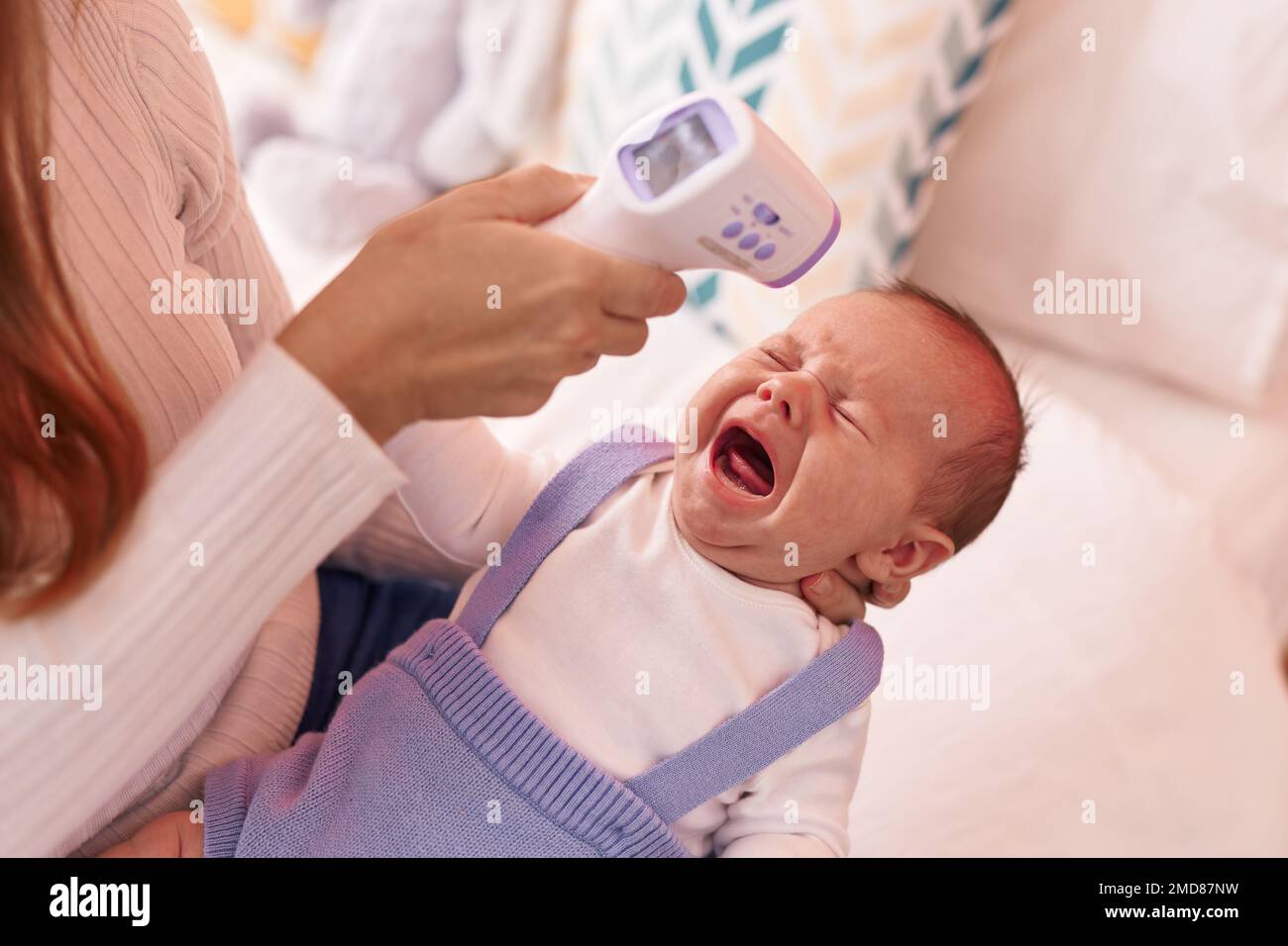 Mother and son measuring fever using thermometer at home Stock Photo ...