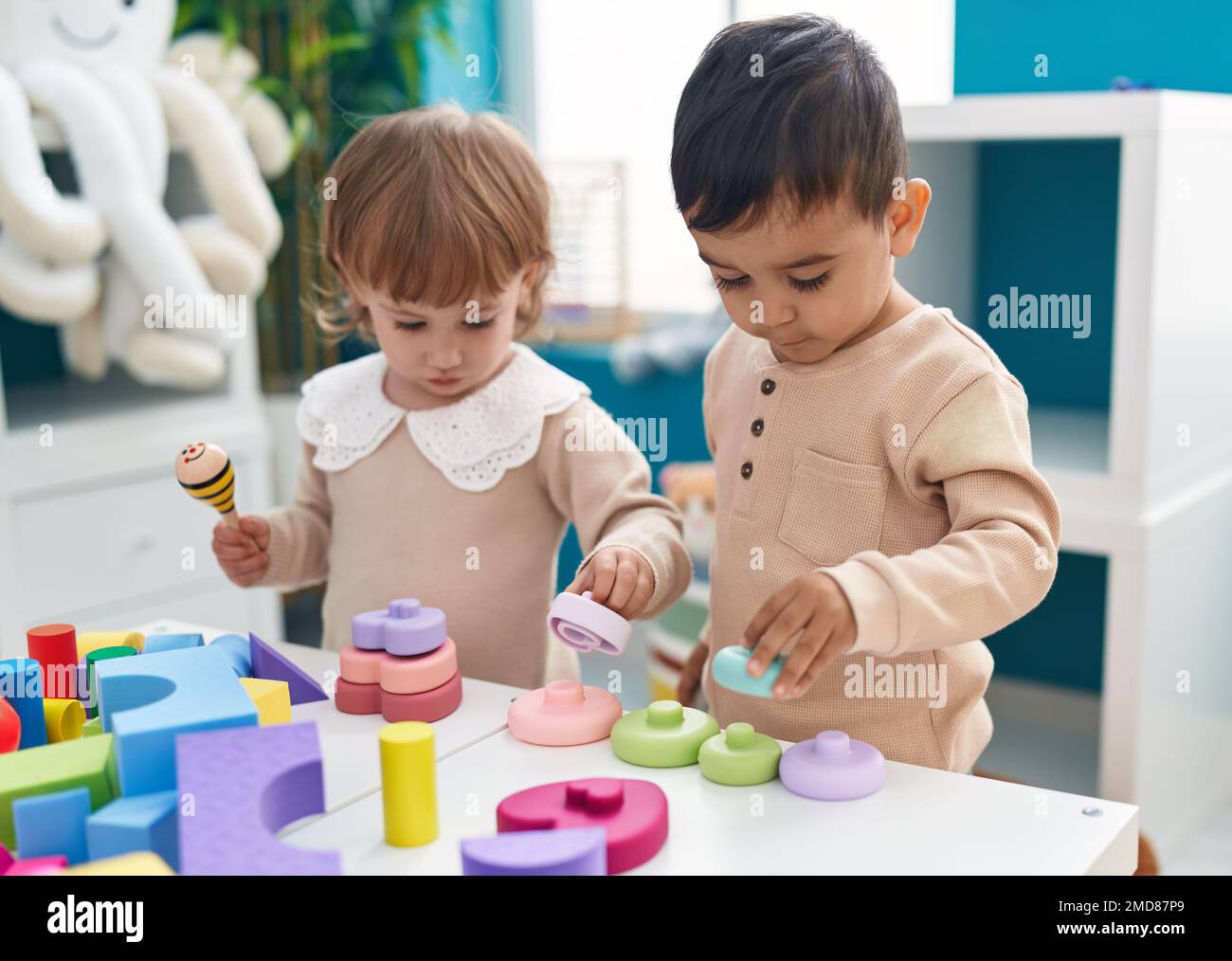 Two kids playing with construction blocks standing at kindergarten ...