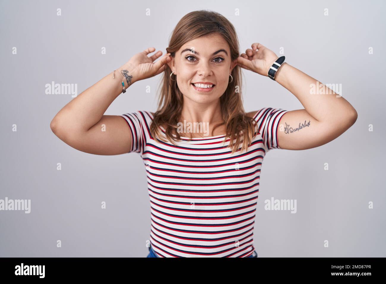 Young hispanic woman standing over isolated background smiling pulling ...