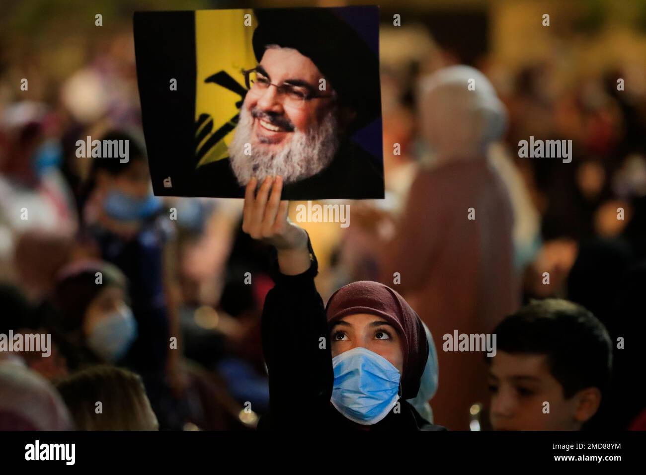 A supporter of Hezbollah group holds up a portrait of Hezbollah Leader ...
