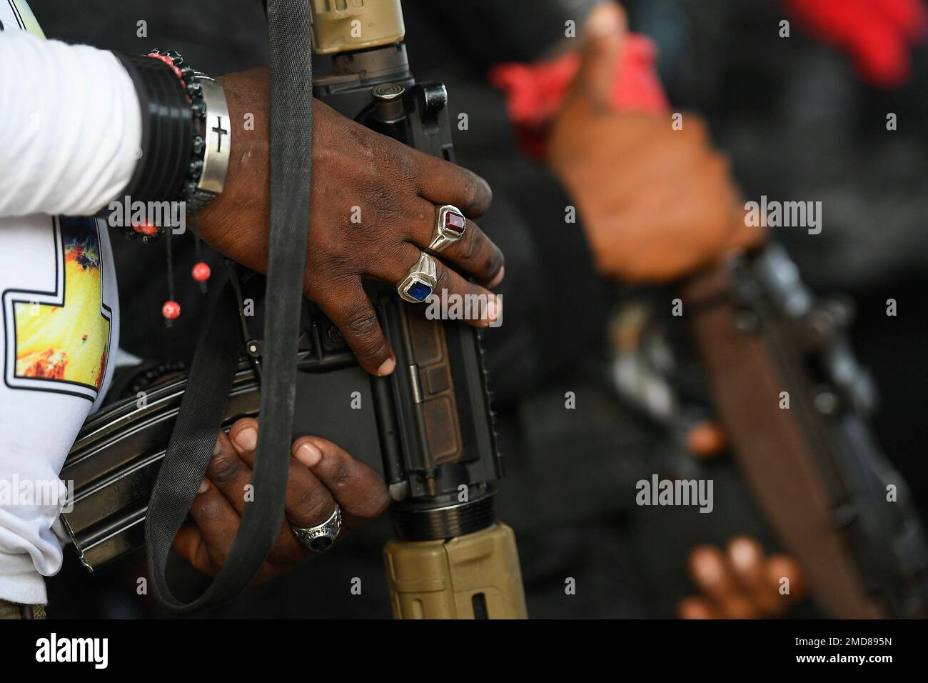 Members of the "G9 and Family" gang hold weapons as the group marches ...